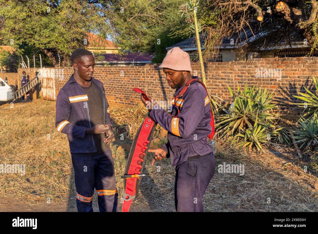 installing optic fiber outdoors, two african technicians, in ...