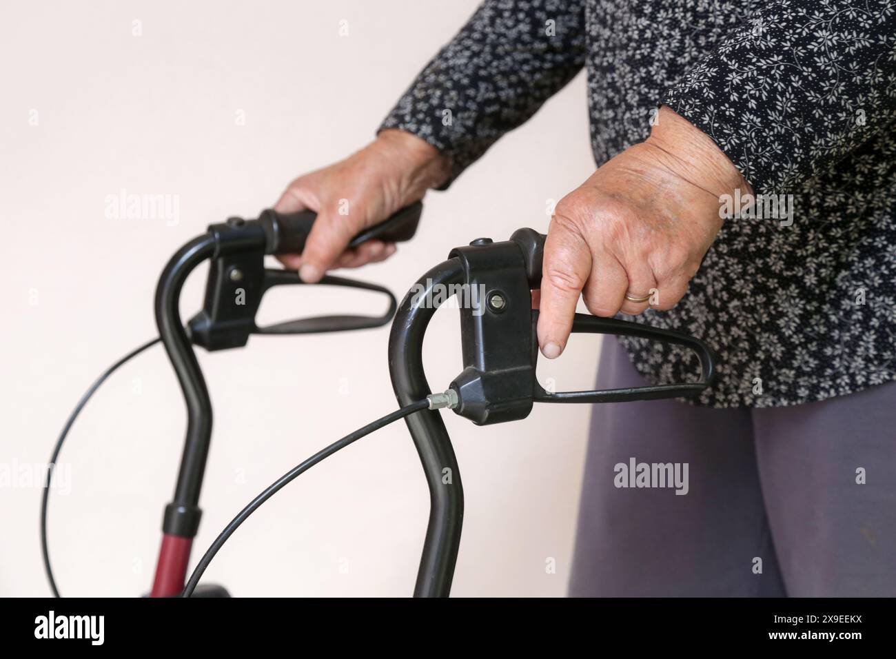 Walking disabilities. Close up of senior disabled woman leaning on her rehabilitation walker ...