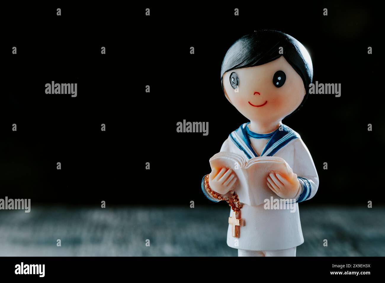 closeup of a figurine of a first communion boy, wearing a white sailor ...