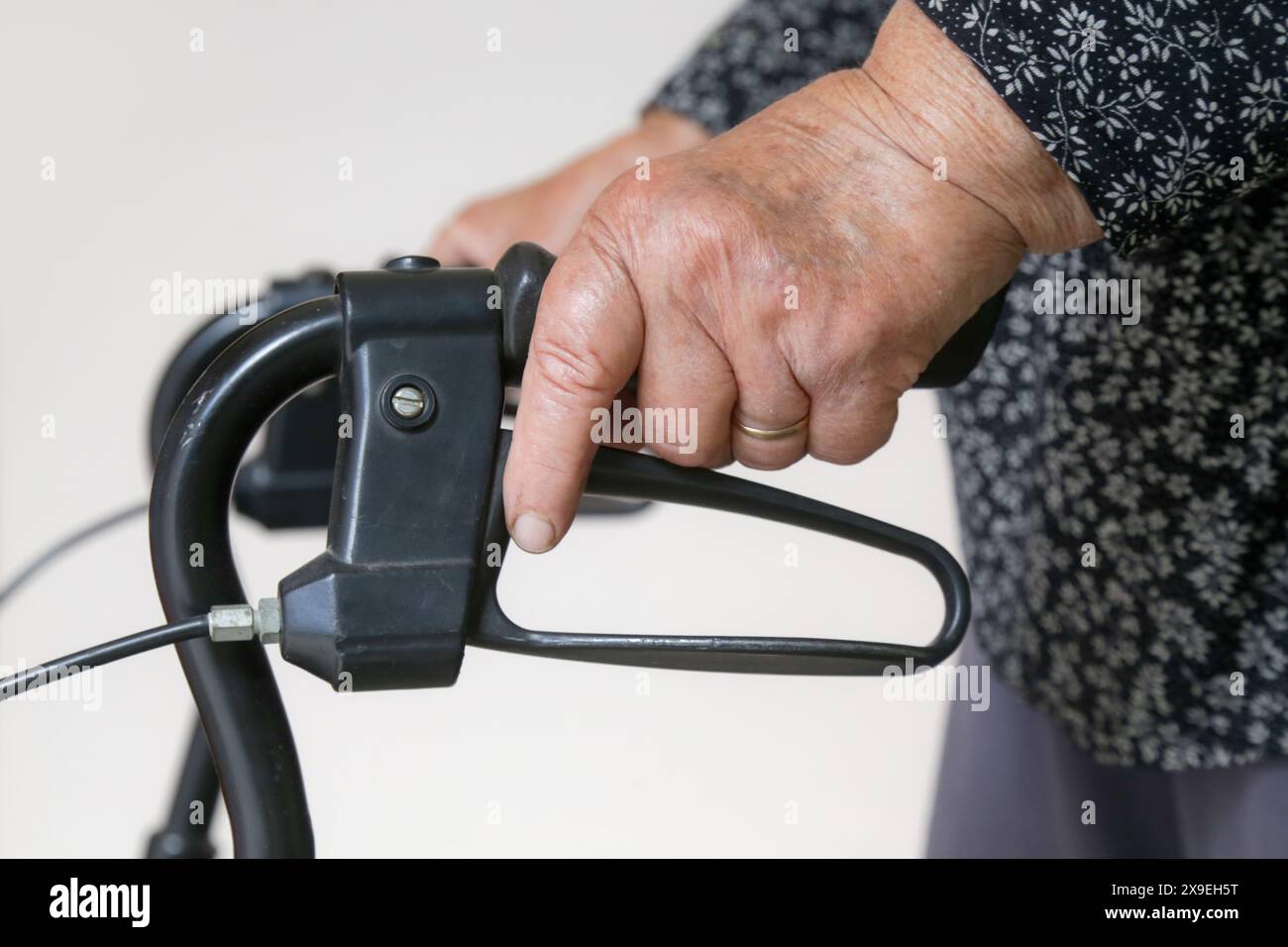 Walking disabilities. Close up of senior disabled woman leaning on her rehabilitation walker ...