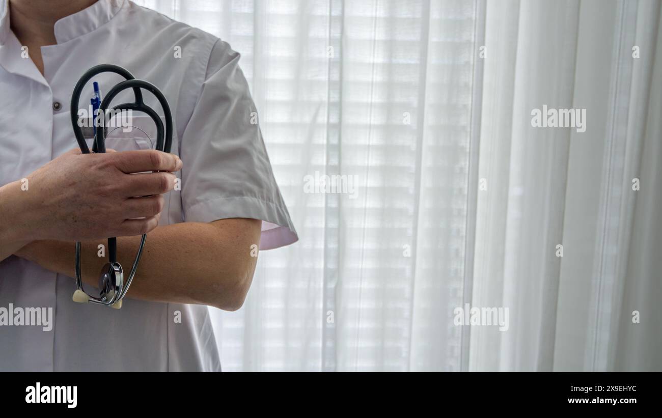 Female doctor or cardiologist in white uniform with stethoscope in hand ...