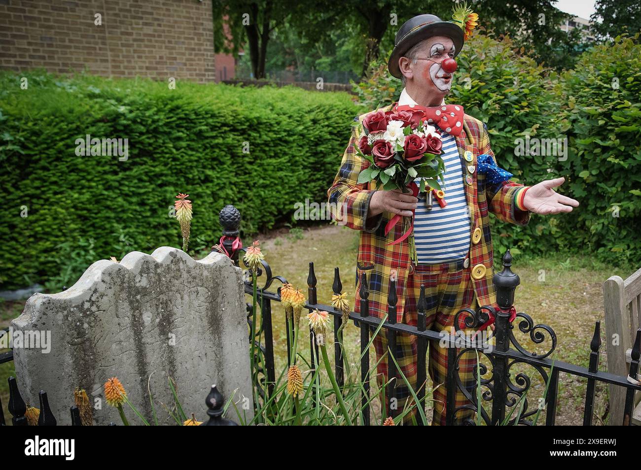 London, UK. 31st May 2024. Clown Mattie Faint prepares to lay flowers ...