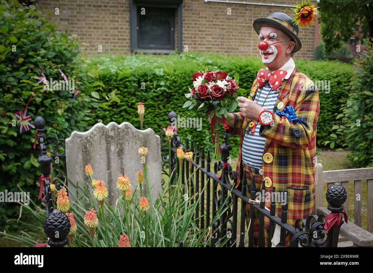 London, UK. 31st May 2024. Clown Mattie Faint prepares to lay flowers ...