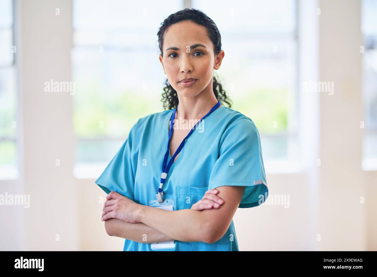 Confident Female Doctor in Hospital Setting Wearing Scrubs and ID Badge ...