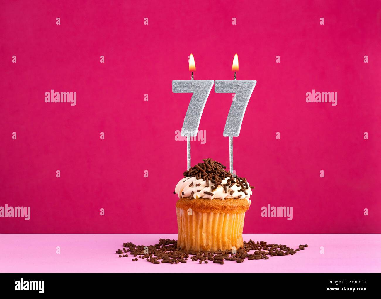 Birthday cupcake with candle number 77 - Birthday card on pink ...