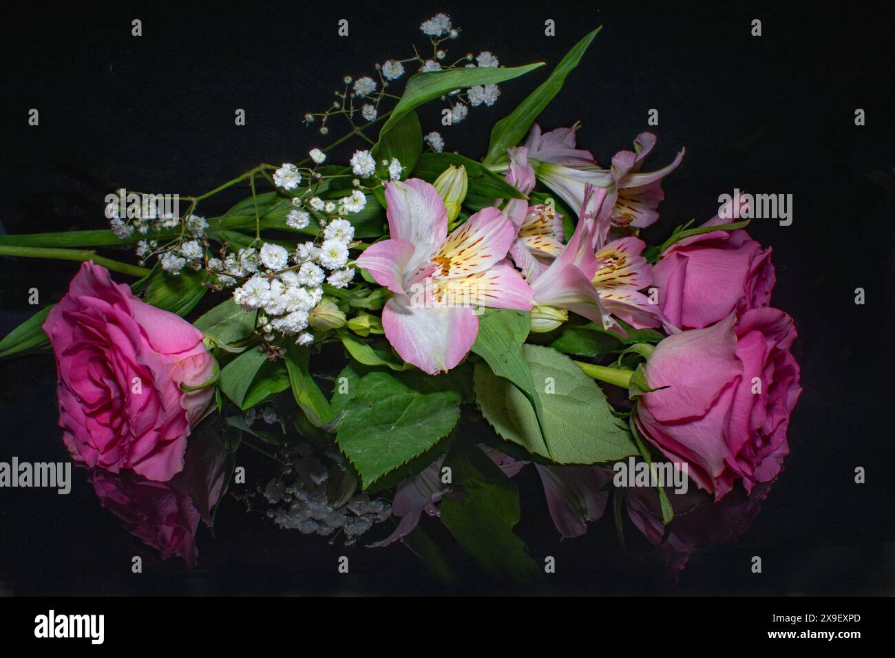 A gorgeous reflection Roses and pink flower arrangement on a shiny ...