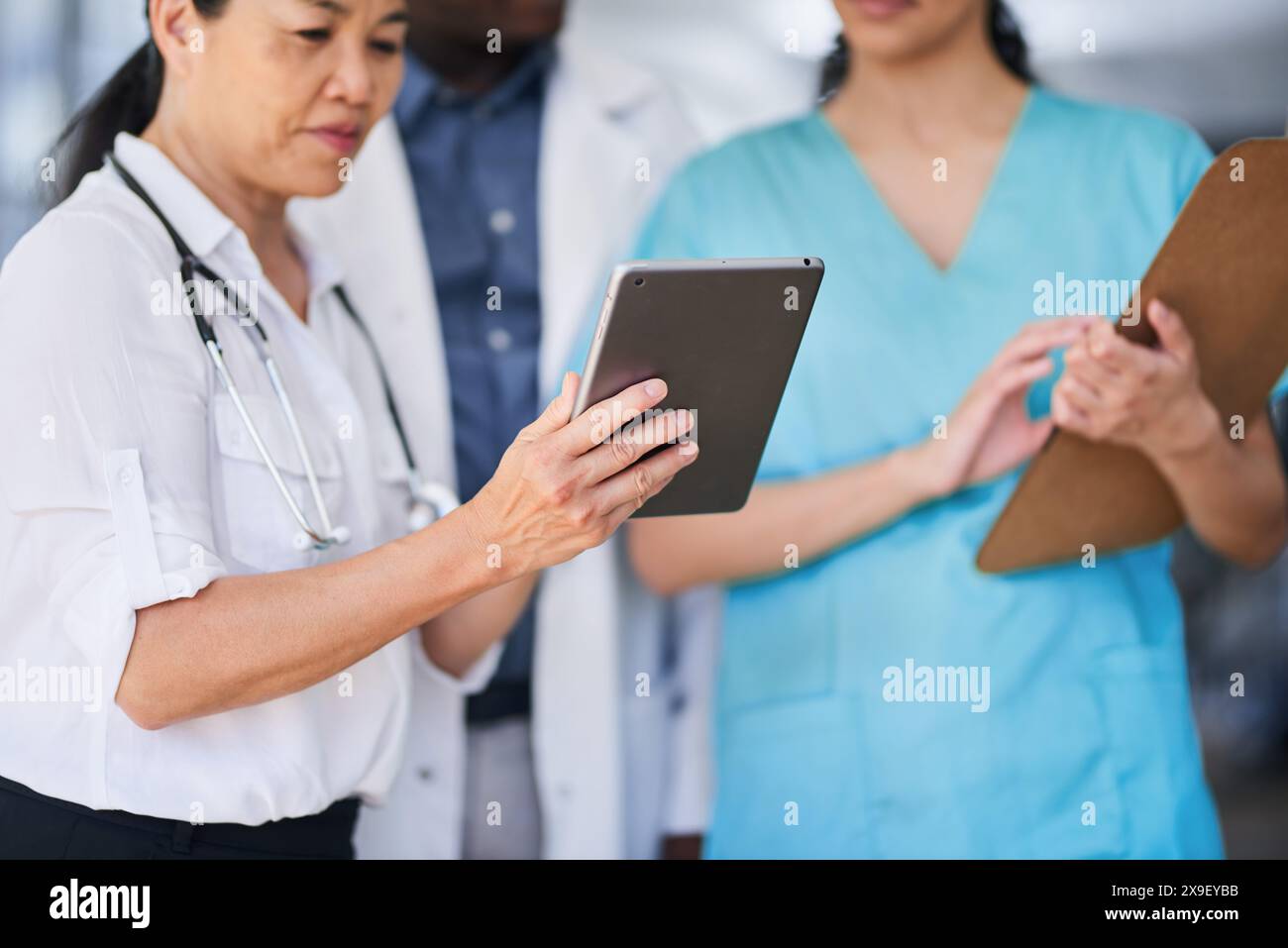 Diverse Medical Team Collaborating With Digital Tablet And Clipboard ...