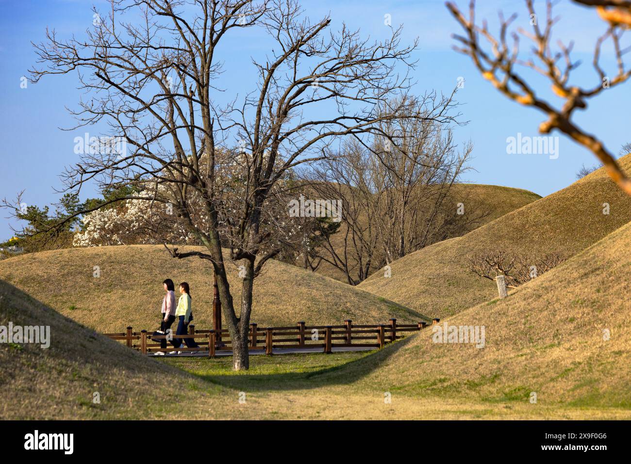Women walking through Daereungwon Tomb Complex (UNESCO World Heritage ...