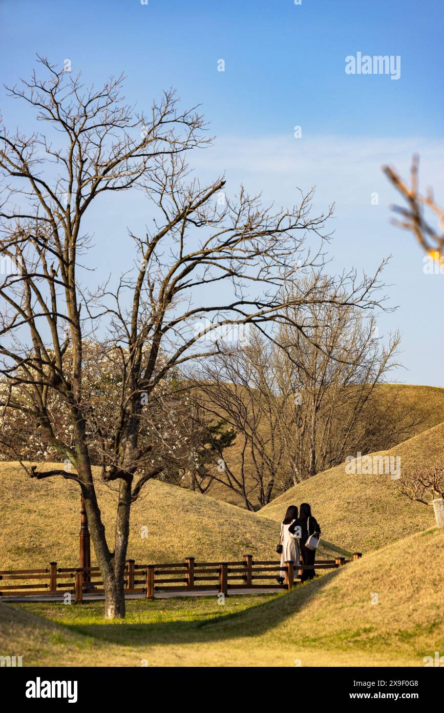 Women walking through Daereungwon Tomb Complex (UNESCO World Heritage ...