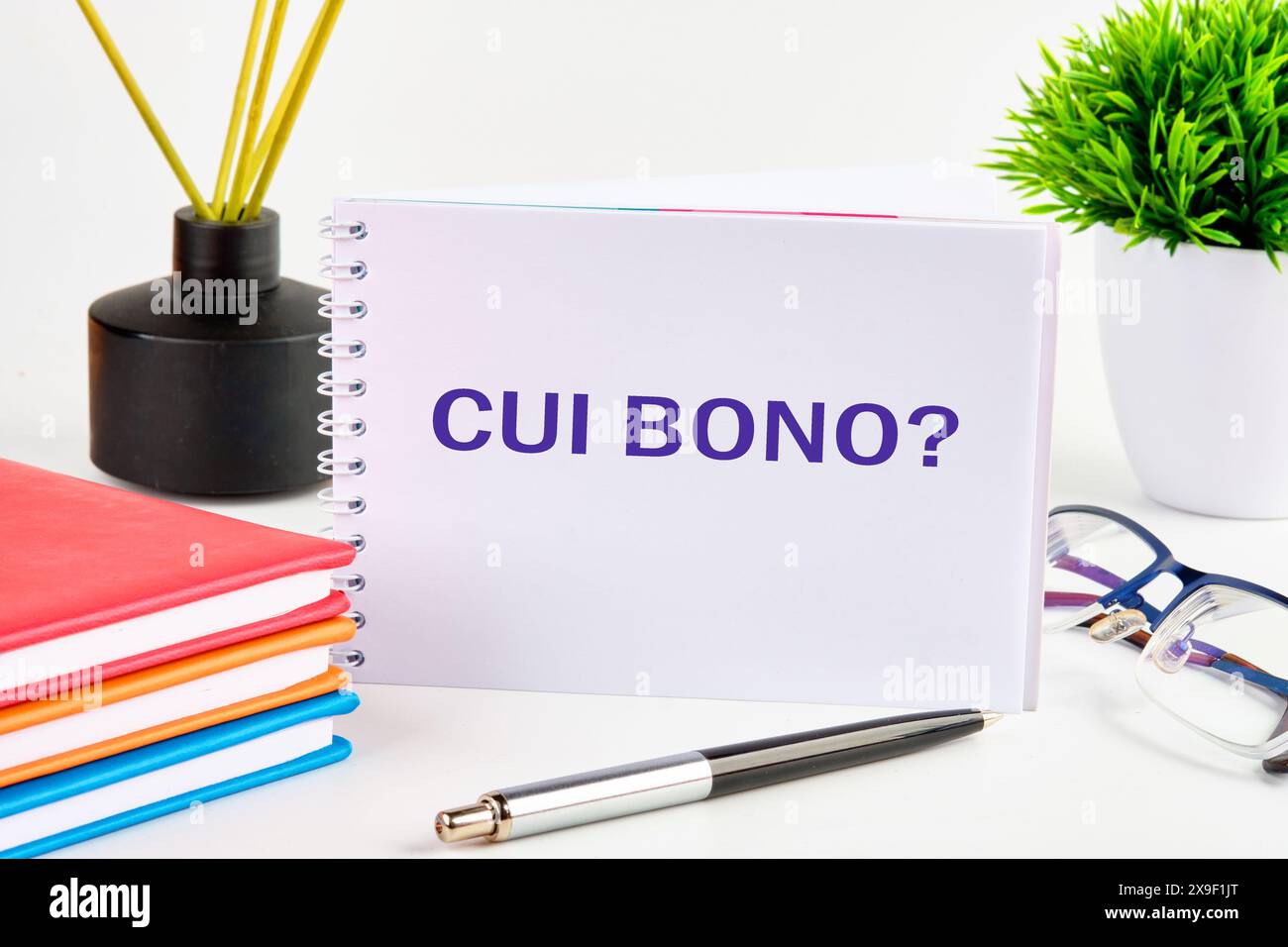 CUI BONO (to whose benefit) question on a standing notebook on a white ...