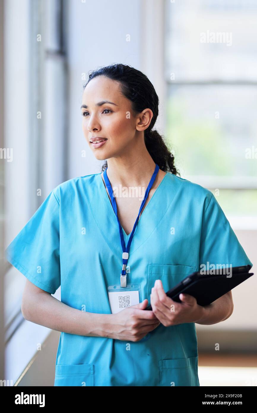 Confident Female Nurse Holding Tablet in Hospital Corridor Stock Photo ...