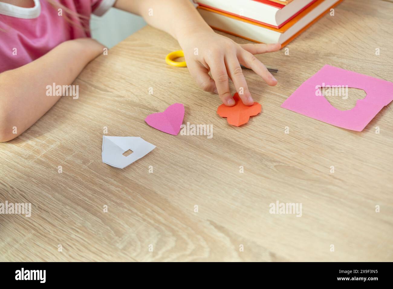 preschooler girl practicing scissor skills by cutting out shapes such ...