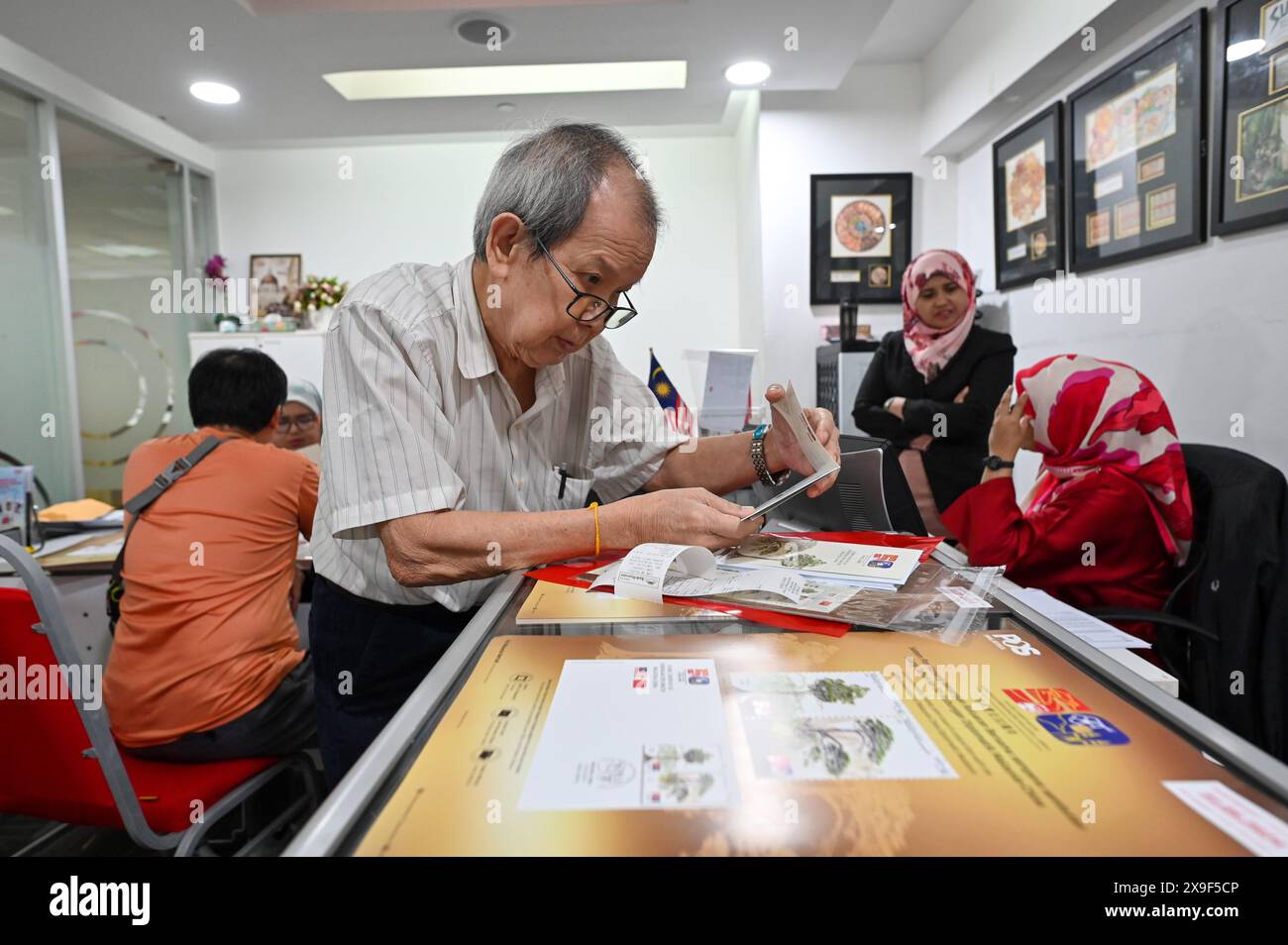 (240531) -- KUALA LUMPUR, May 31, 2024 (Xinhua) -- A customer purchases stamps marking the 50th ...