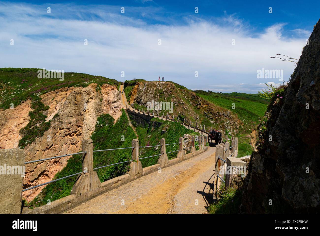 Woman driving horse drawn carriage across vertiginous land bridge La ...