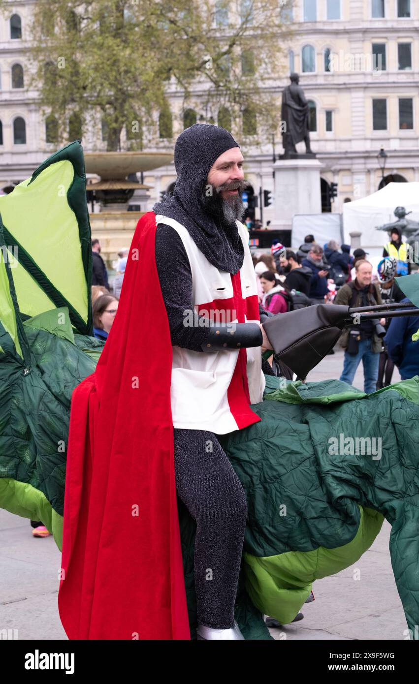 Performer dressed as St. George and riding a green dragon, meeting and ...