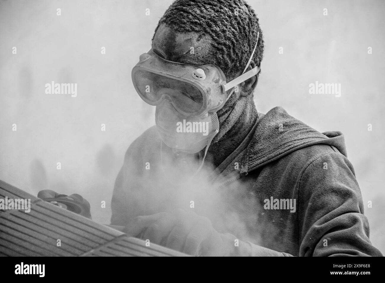 A workman grinding out the lip of old fibreglass and making dust Stock ...