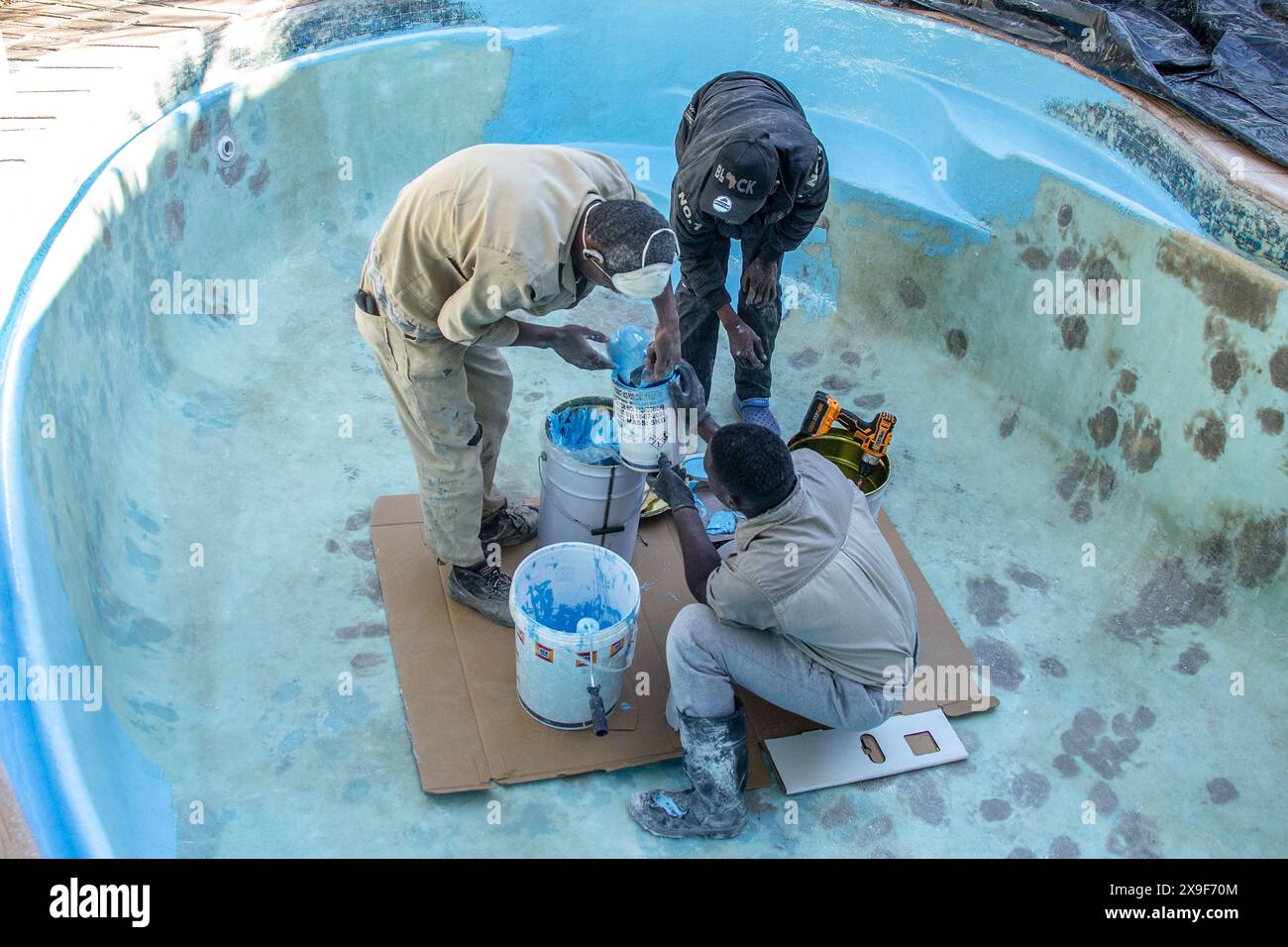 Workmen carefully measuring and mixing gel coat and hardener to cover ...