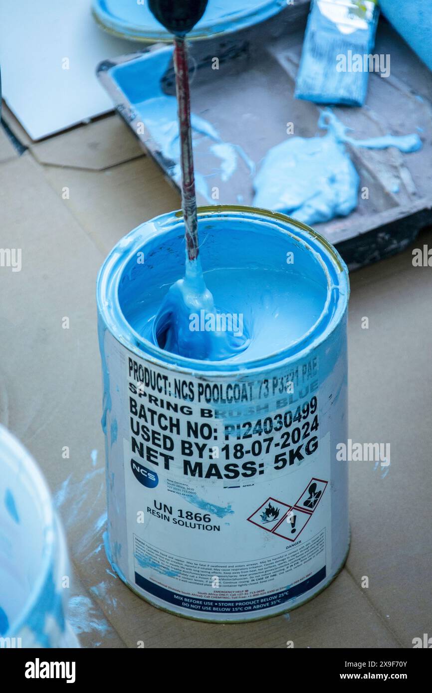 Workmen mixing blue gel coat and hardener with an electric drill to ...