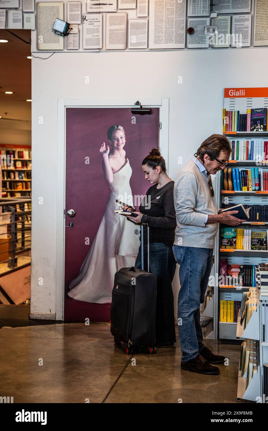 Two people reading books inside cozy bookstore setting Stock Photo - Alamy