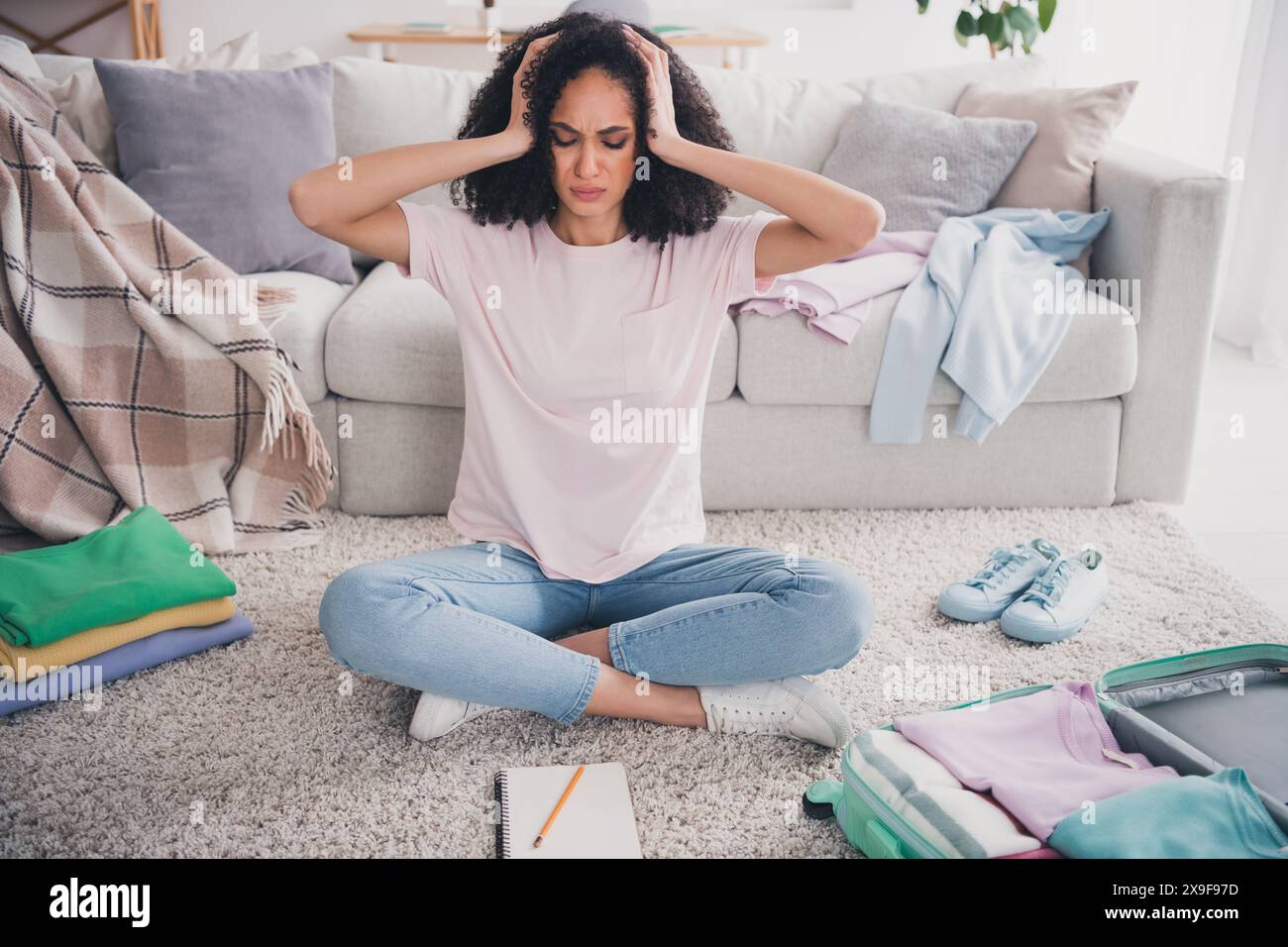 Photo of stressed depressed cute girl sitting floor preparing clothes ...