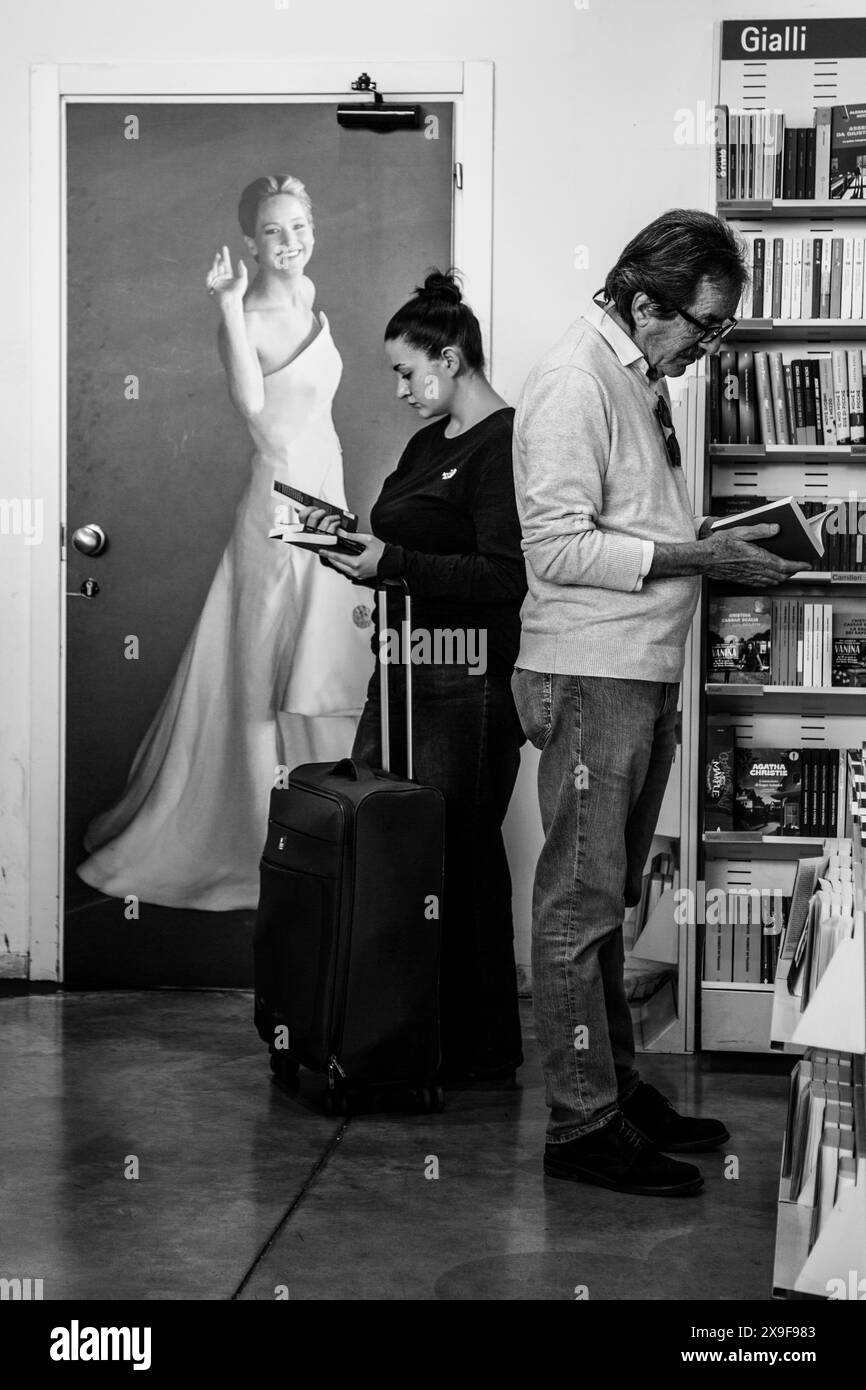 Two people reading books inside cozy bookstore setting Stock Photo - Alamy