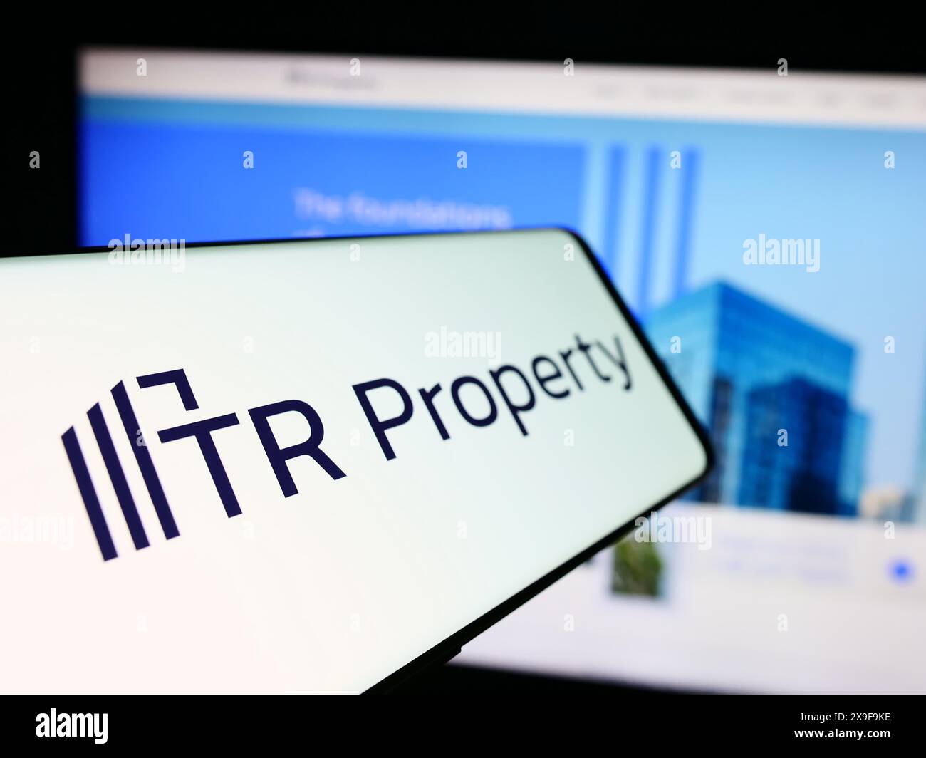 Mobile phone with logo of British company TR Property Investment Trust plc in front of business ...