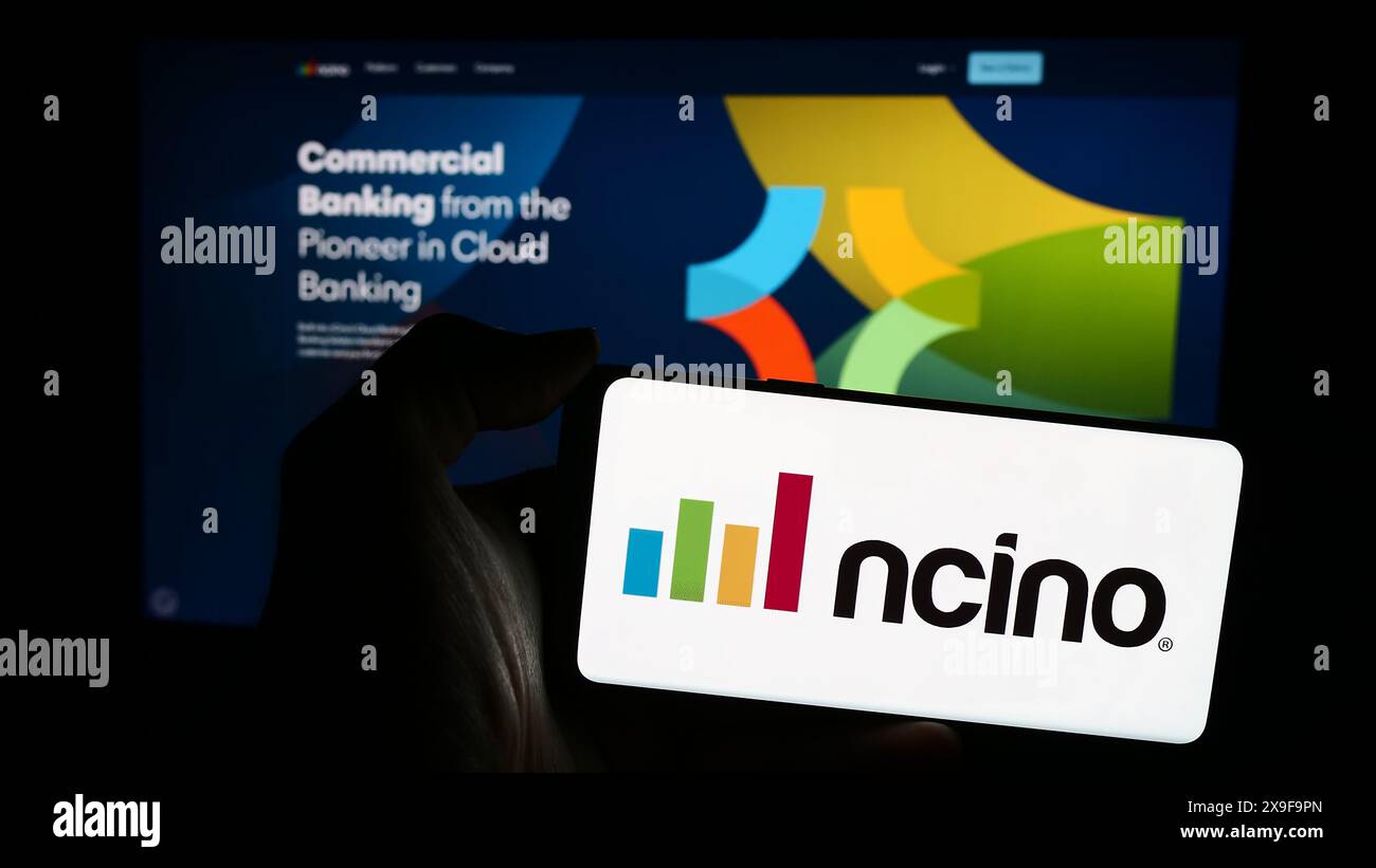 Person holding mobile phone with logo of American financial technology ...