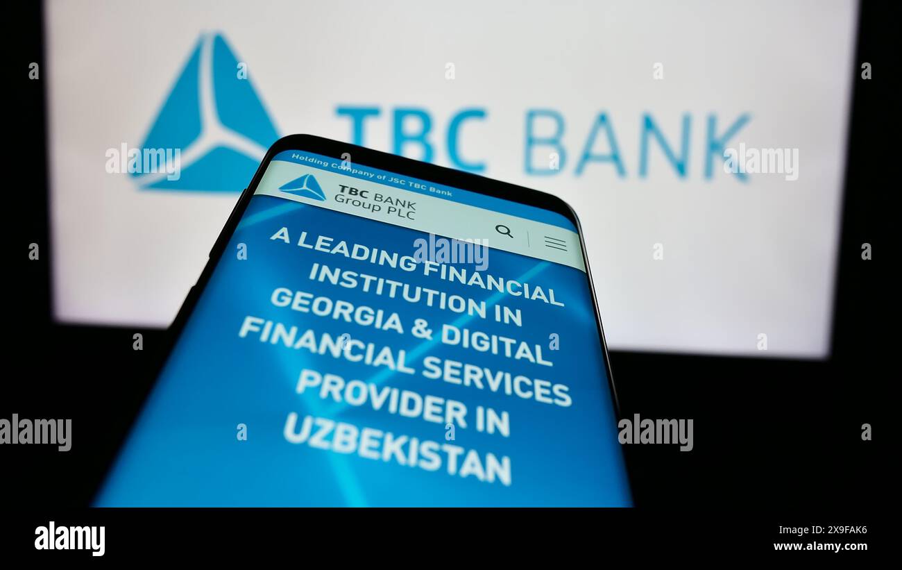 Mobile phone with webpage of Georgian financial services company TBC Bank Group plc in front of ...