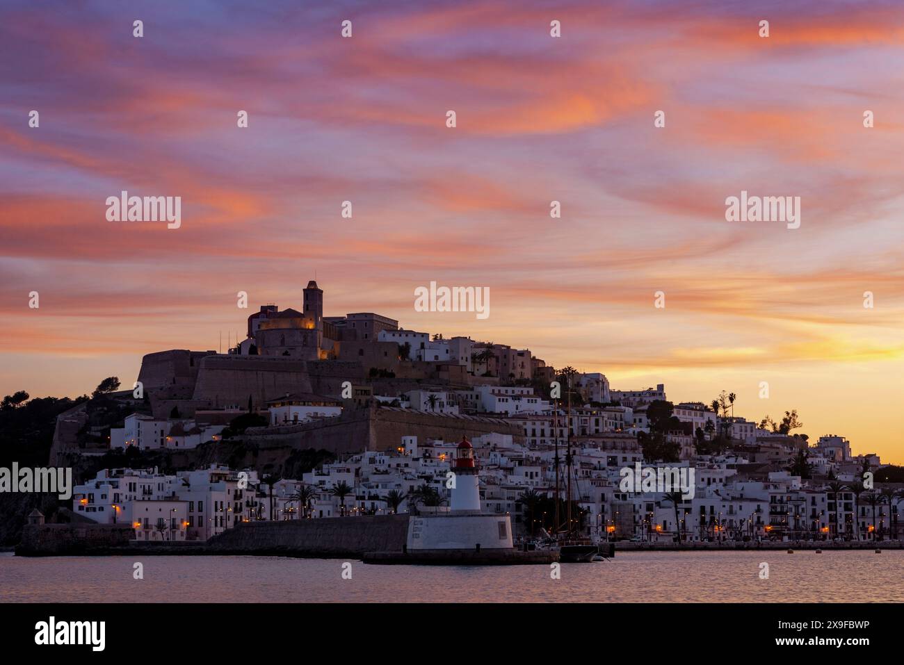 View into land of the Old town and lighthouse at sunset, Ibiza ...