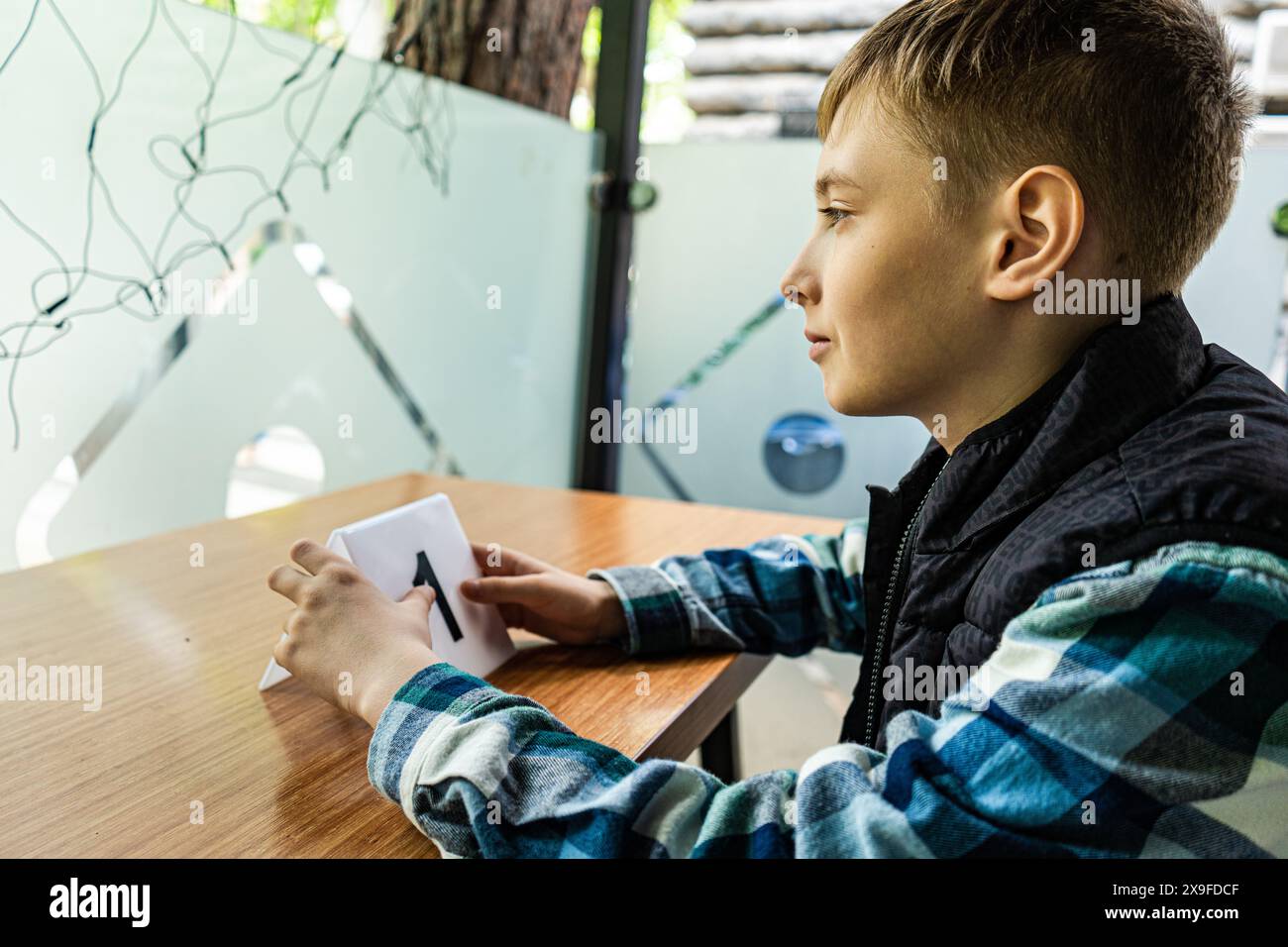 Boy sitting in a cafe with a position number waiting for food Stock ...
