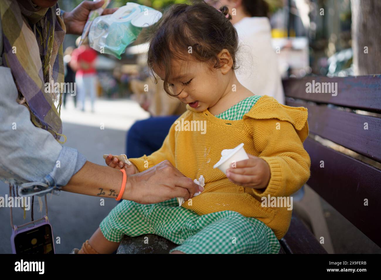 Baby girl trying ice cream gelato for the first in summer in city ...