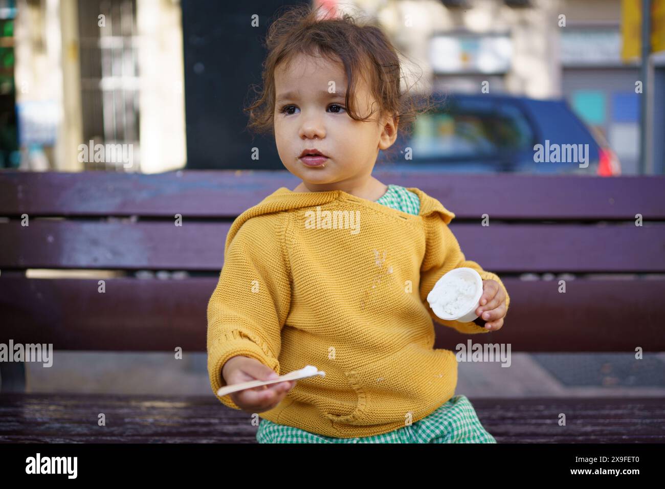 Baby girl trying ice cream gelato for the first in summer in city ...