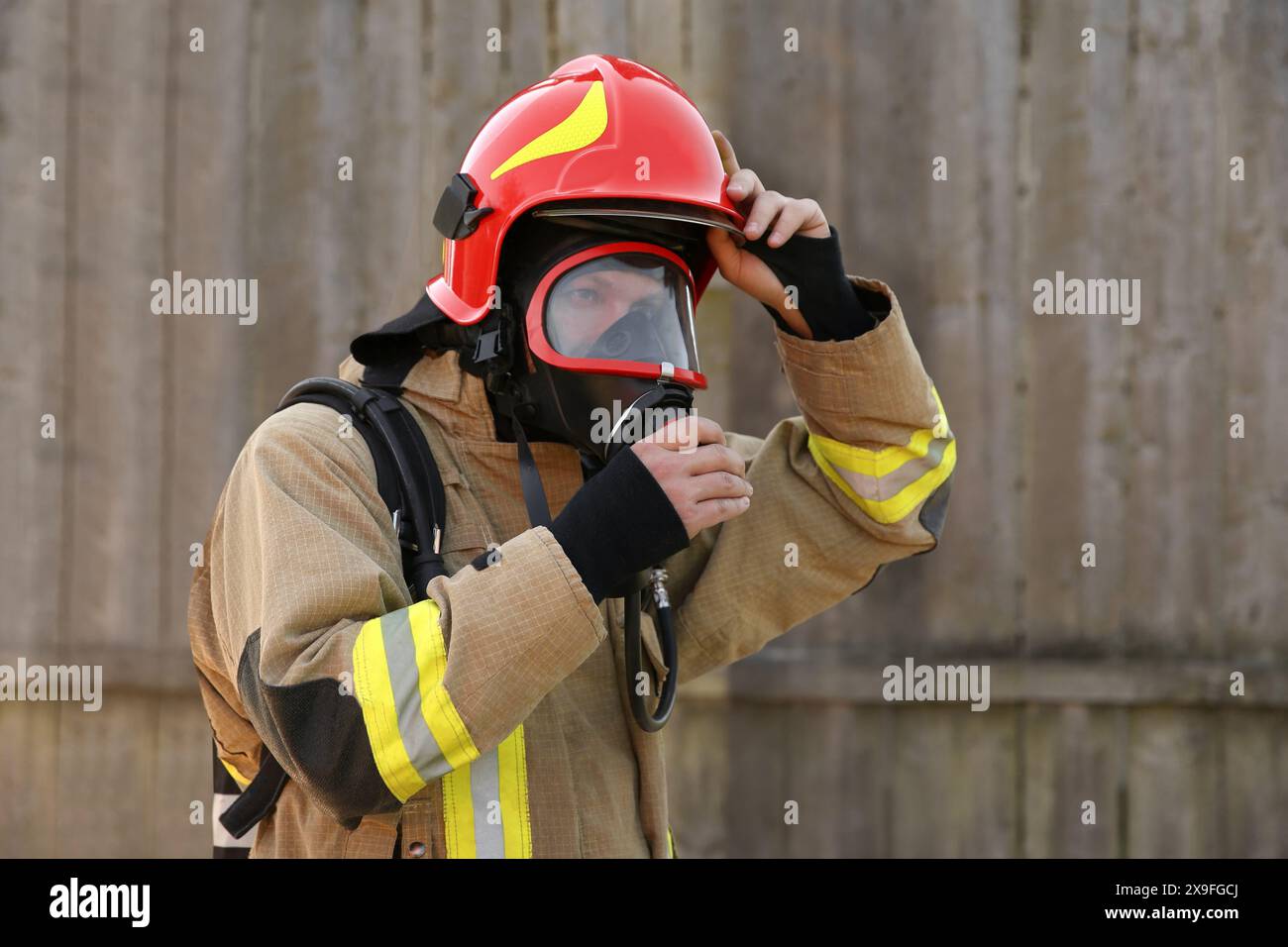 Firefighter in uniform wearing helmet and mask outdoors Stock Photo - Alamy