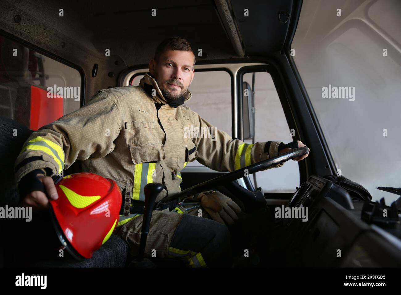Firefighter in uniform with helmet driving modern fire truck Stock ...