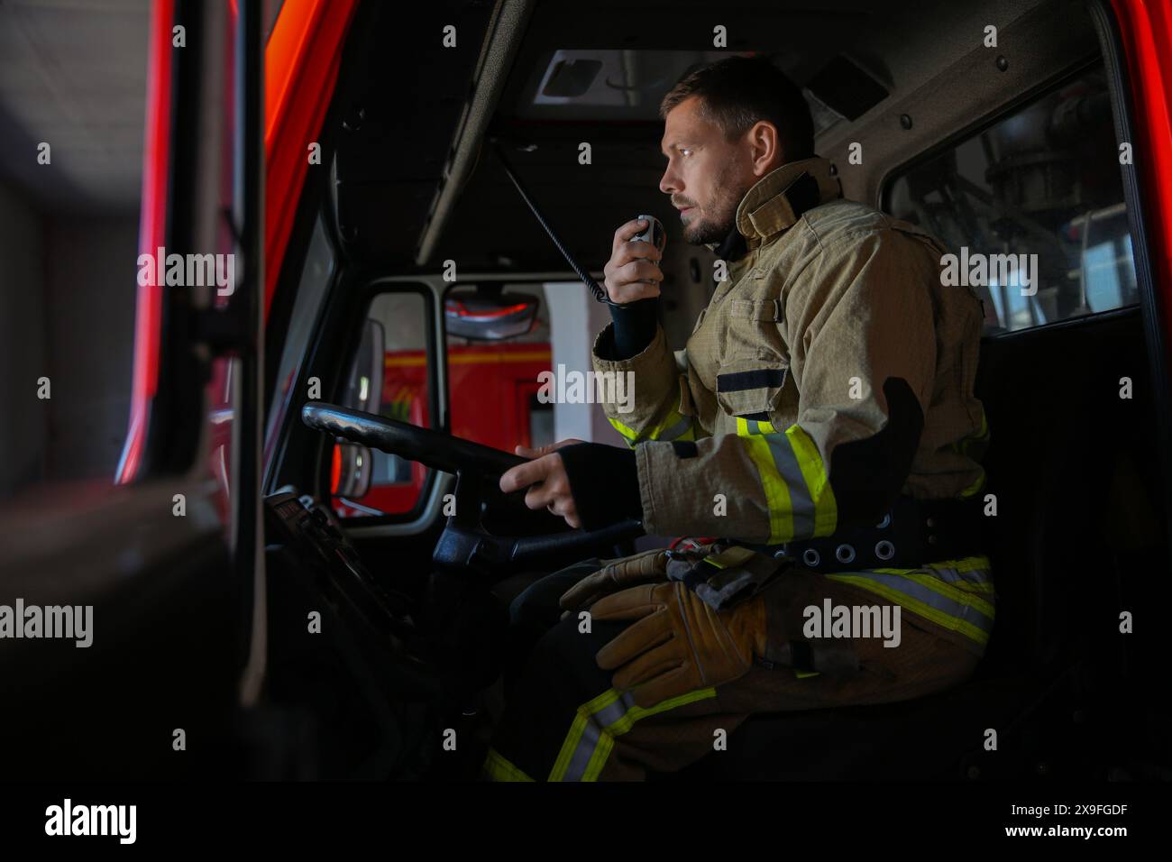 Firefighter using portable radio set while driving fire truck Stock ...