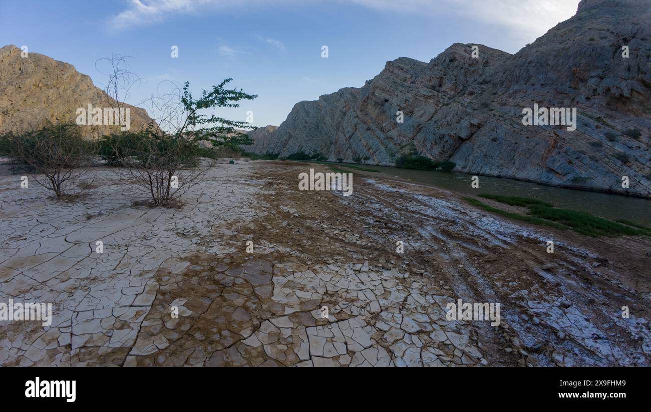 Photography of dried up riverbed with mud and tyre tracks next to a ...