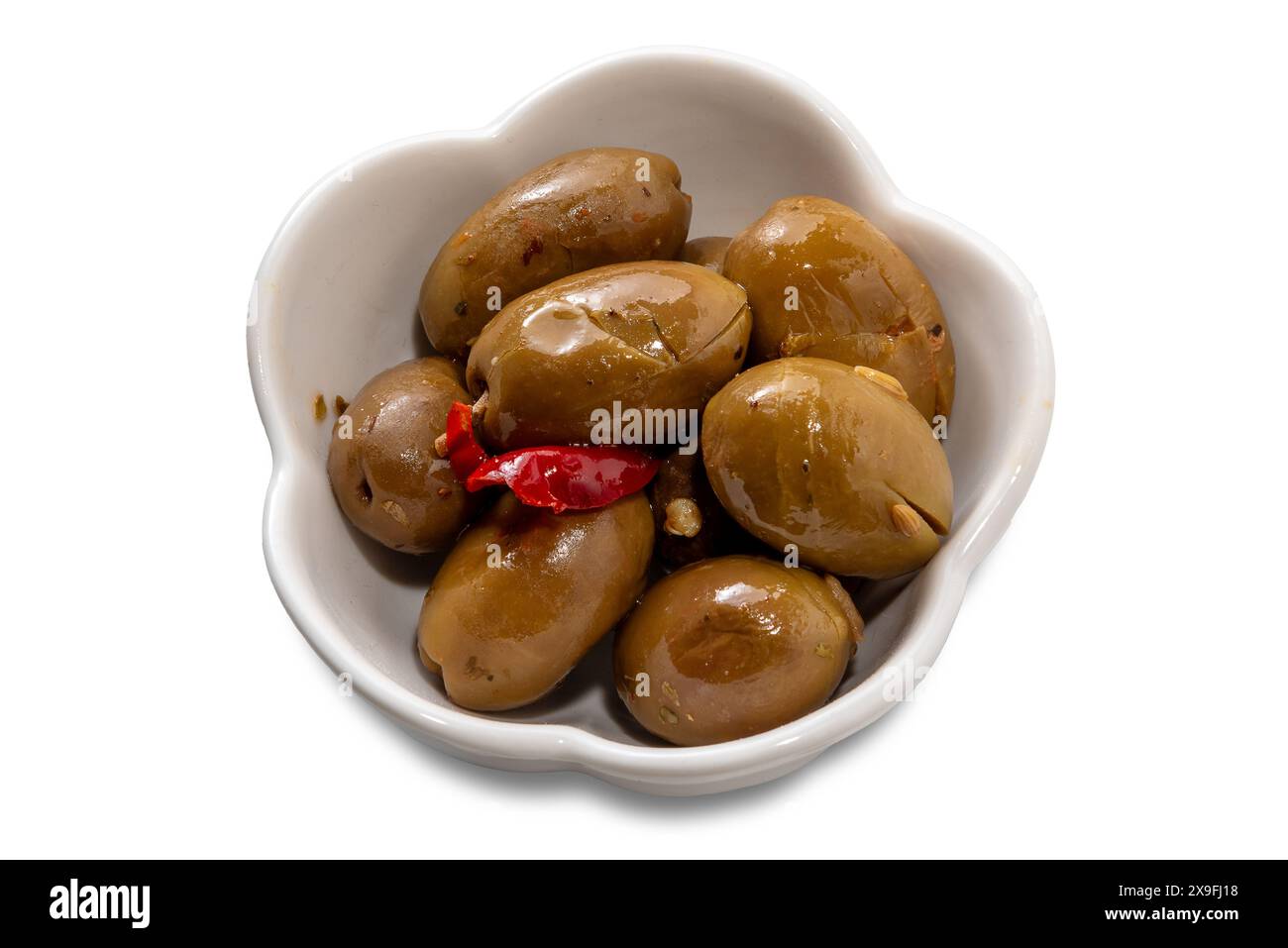 Seasoned green olives in white ceramic cup isolated on white with ...