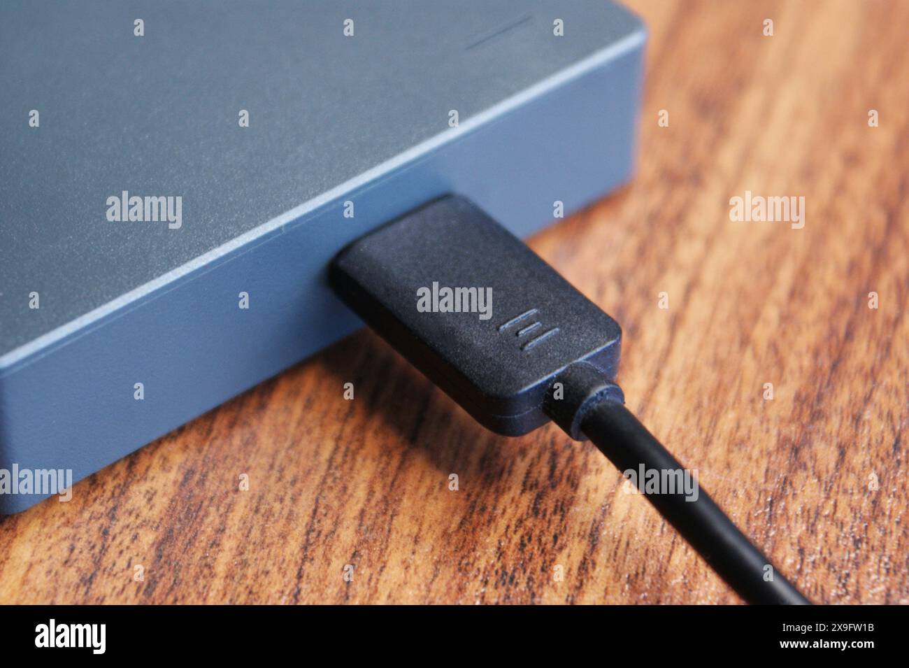 External hard drive on dark wooden table with cable attached Stock ...