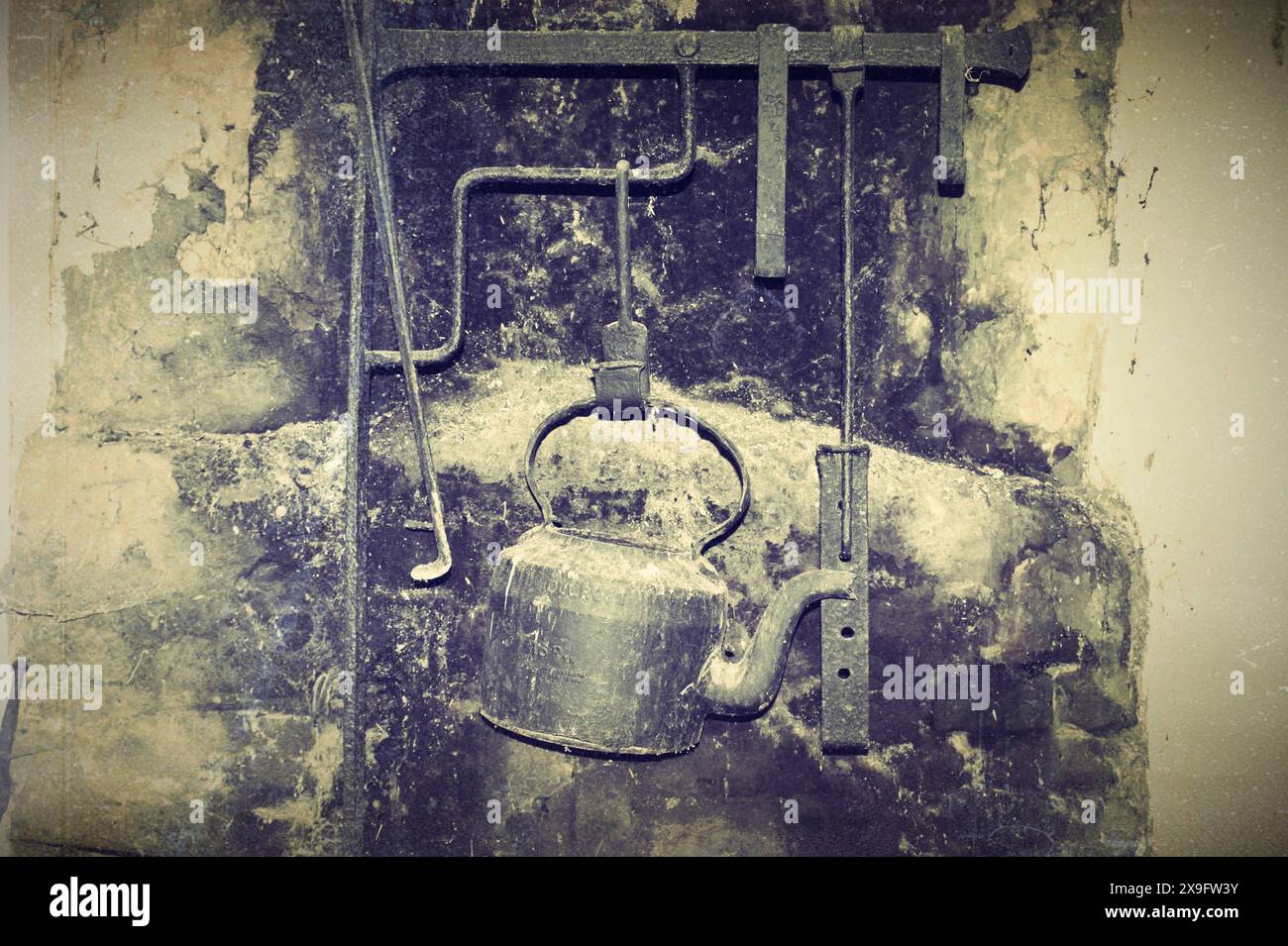 An old kettle on a hook, hanging over the hearth. Old photo Stock Photo ...