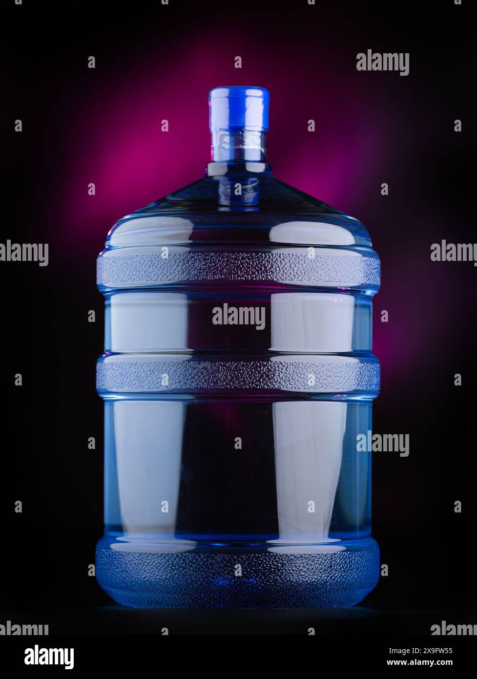 large gallon of water on a black background with pink tints Stock Photo ...