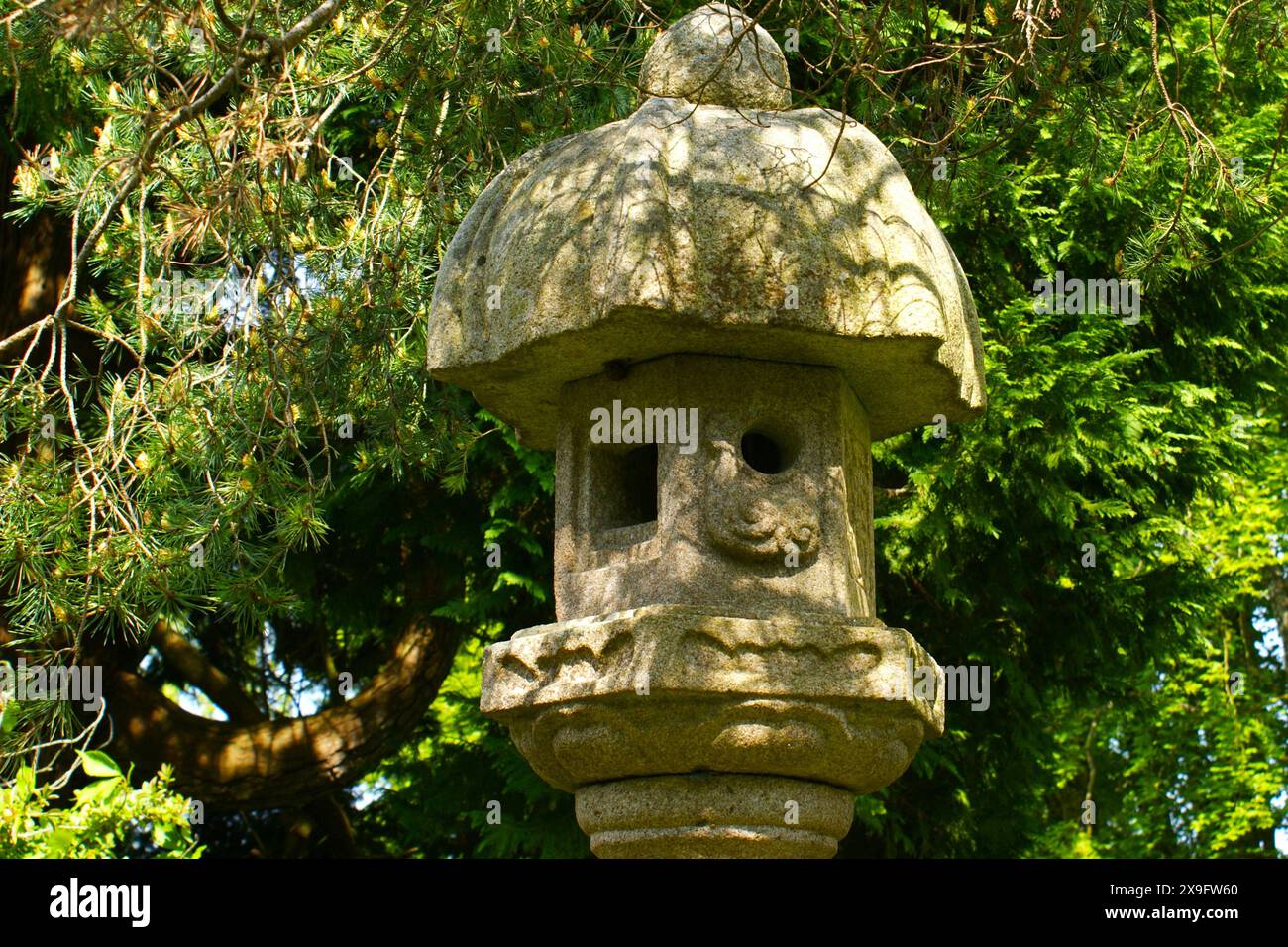 A traditional Japanese toro lantern made of stone placed in a park ...