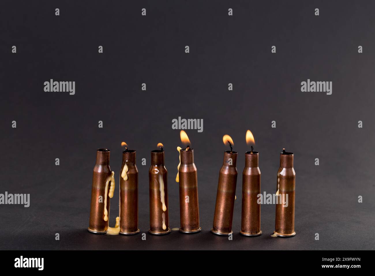 Burning candles and empty rifle cartridges. As a symbol of war and ...