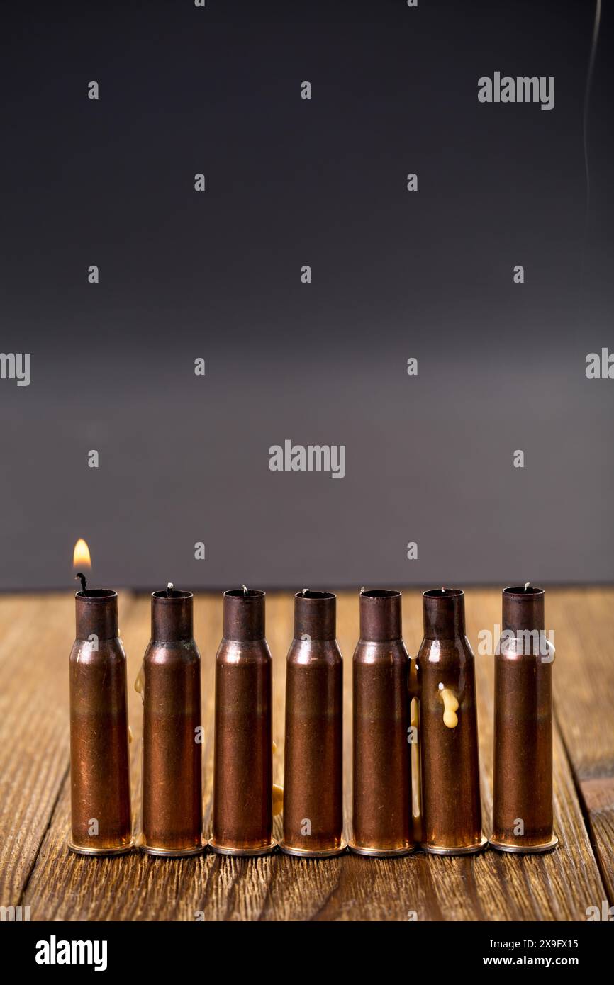 Burning candles and empty rifle cartridges. As a symbol of war and ...