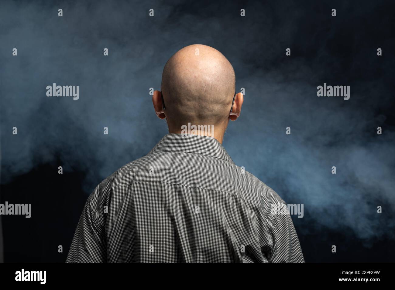 Bald middle-aged man with his back to the camera. Isolated on studio ...