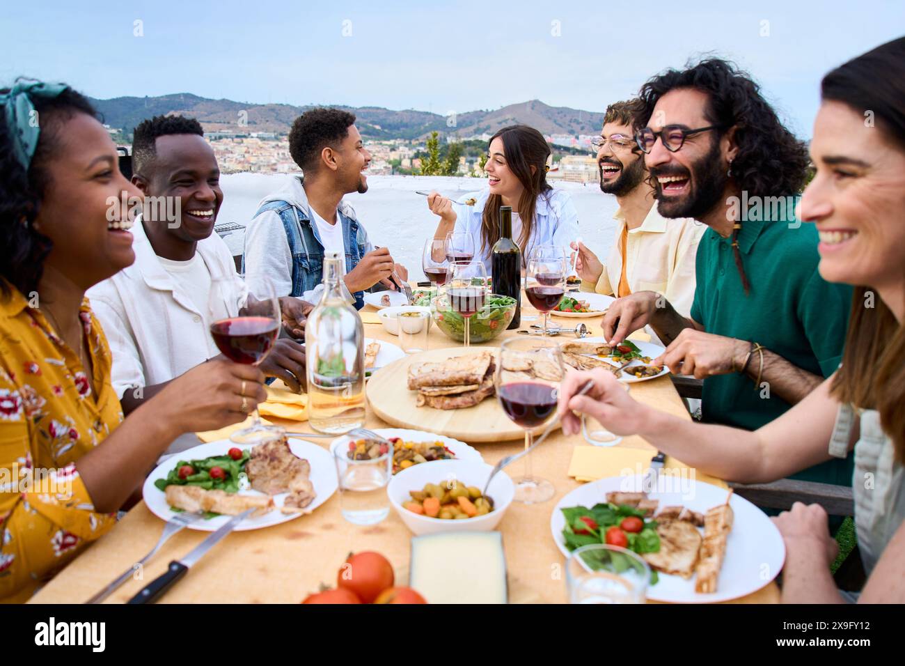 Happy people around meal table with wine glasses and food celebration ...