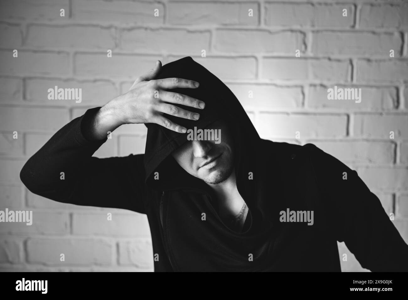 A man wearing a black hoodie is energetically dancing with expressive ...