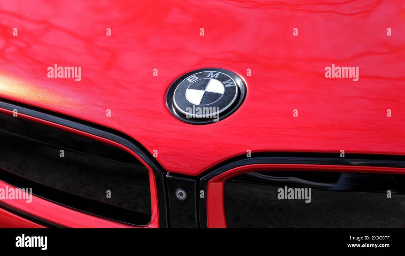 A logo of BMW on a front part of a red car Stock Photo - Alamy