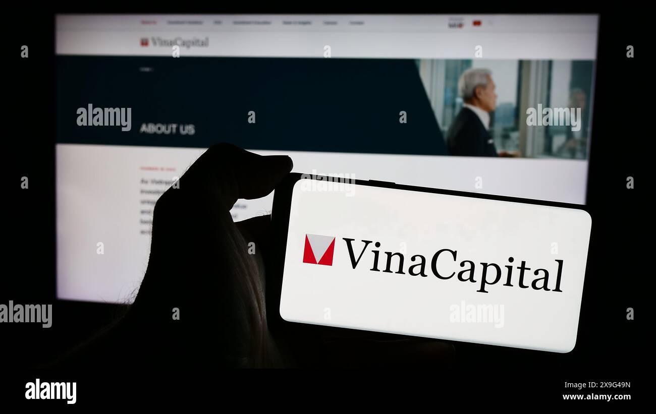 Person holding mobile phone with logo of Vietnamese investment ...