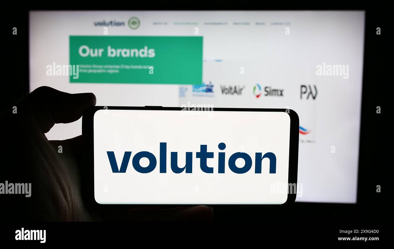 Person holding cellphone with logo of British ventilation equipment ...