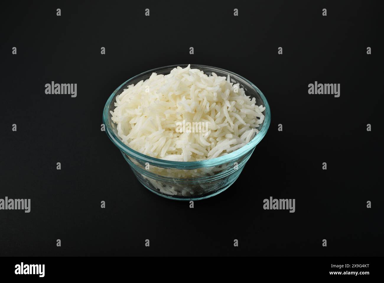 a small serving of basmati rice in a glass bowl on a black background ...